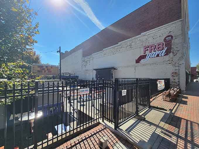 That vintage brick wall and wrought-iron fencing frame a perfectly relaxed afternoon where good food meets great company.