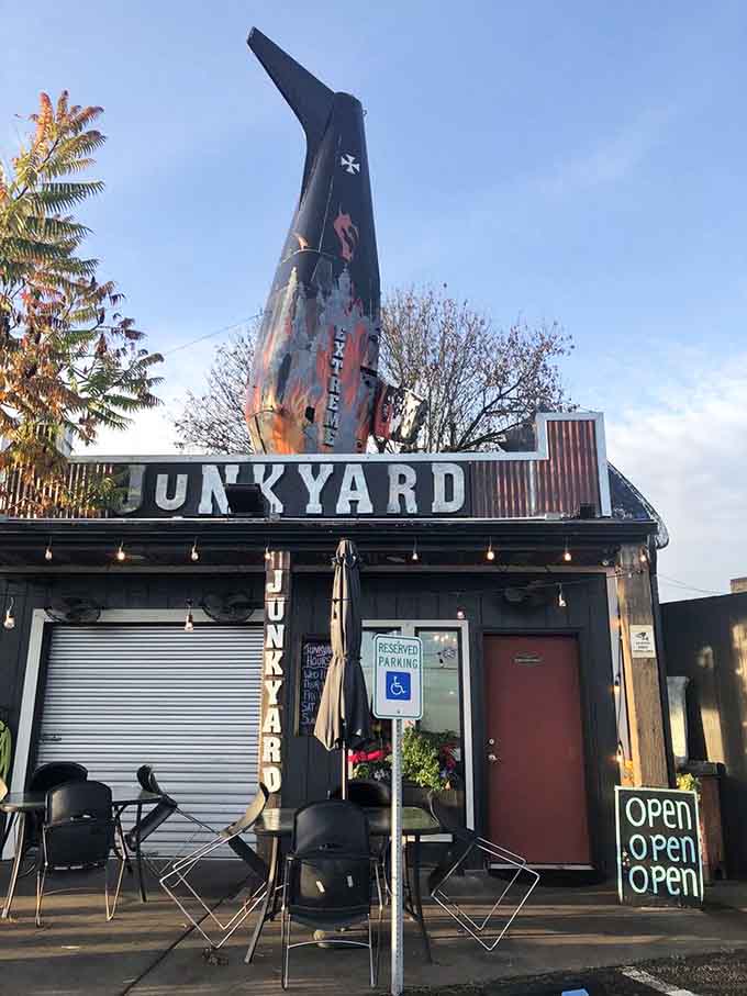 The weathered junkyard aesthetic creates an atmosphere where extreme burgers feel right at home among salvaged treasures.
