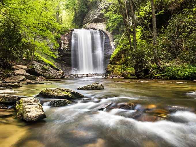 Moss-covered boulders frame the rushing stream below this elegant waterfall, creating nature's own zen garden without any admission fee.