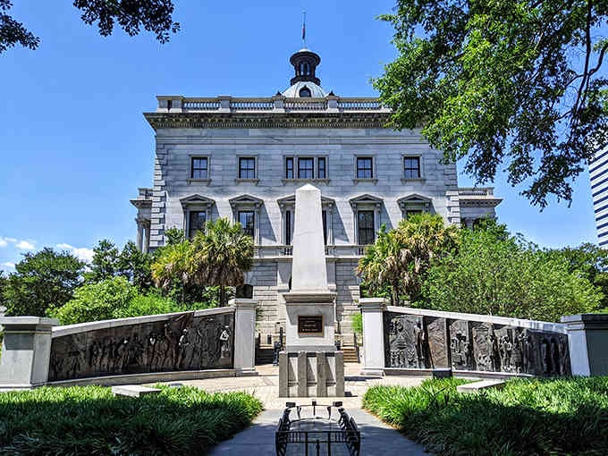 Palmetto trees frame the monument-dotted grounds where history lives in bronze and stone beneath Carolina blue skies.