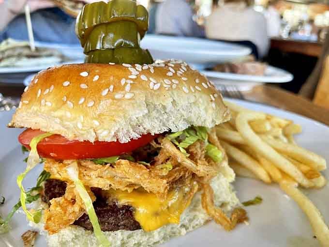 That burger stands taller than your nephew's fish stories, complete with crispy onion strings defying gravity and common sense.