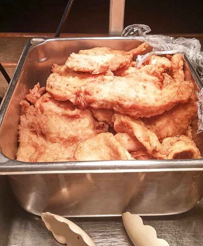 Crispy fried chicken breasts piled high in the pan, waiting to make someone's day absolutely spectacular and delicious.