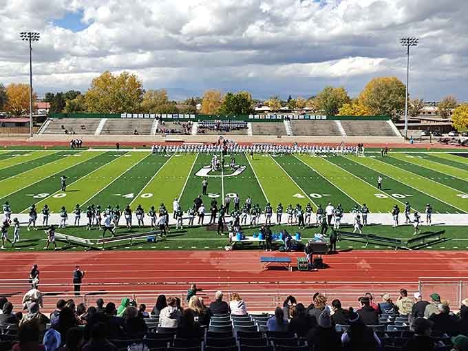 Rex Stadium hosts college football under big skies where autumn colors compete with the surrounding mountain drama.