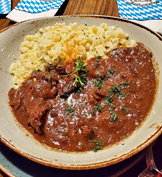 Rich beef goulash pooling around tender sp&auml;tzle like a Bavarian hug in a bowl, pure cold-weather satisfaction.