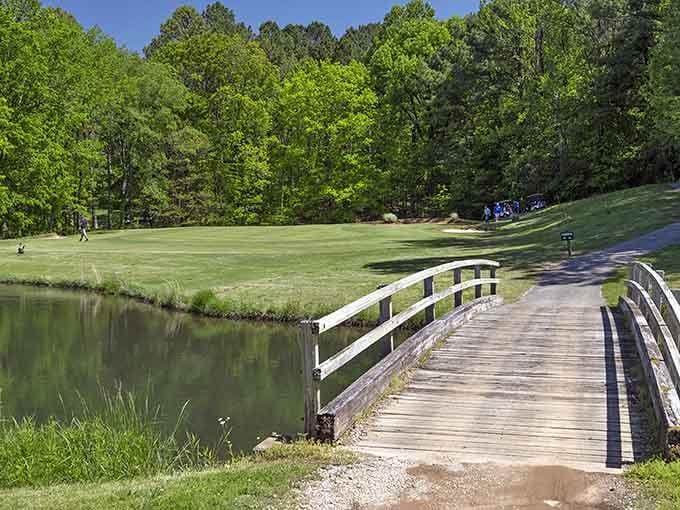 This footbridge leads golfers over tranquil waters toward their next challenging hole and scenic views.