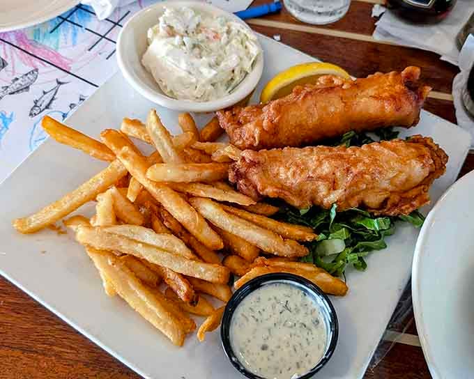 Plated fish and chips that look like they just won the lottery and decided to share their good fortune with you.