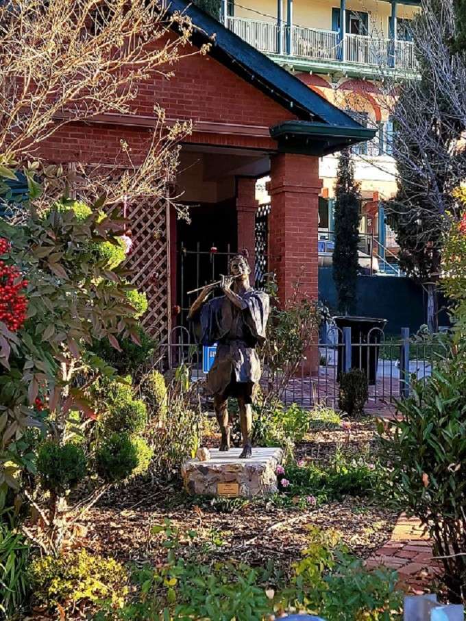 Beautifully sculpted, this bronze figure plays a silent flute, inviting you to pause and enjoy the peaceful garden's timeless melody.