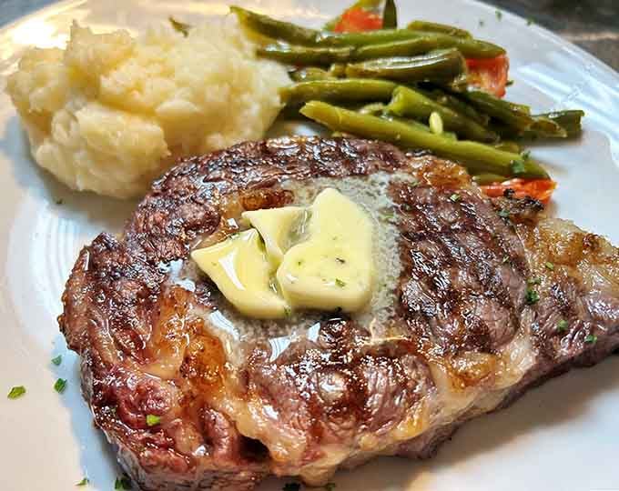 A ribeye with that gorgeous char and herb garnish that makes your mouth water before the first bite.