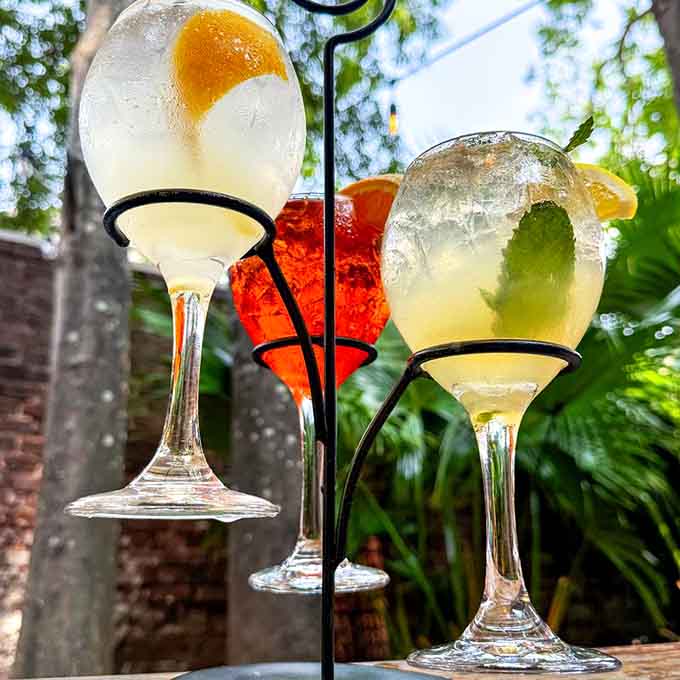 Three cocktails hanging like edible art, proving that presentation matters almost as much as what's inside the glass.