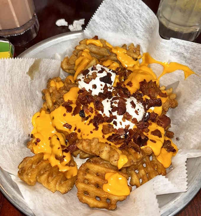 Waffle fries loaded with cheese and bacon prove that vegetables are merely suggestions, not requirements for happiness.