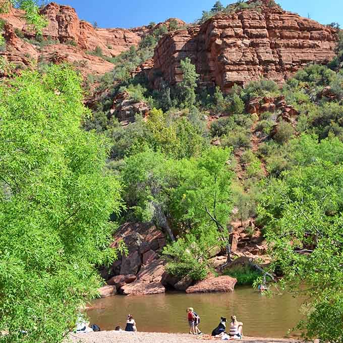 Emerald vegetation hugs the shoreline while towering cliffs create a natural amphitheater that makes every splash echo beautifully.