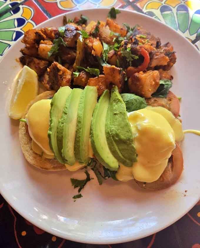 Eggs Benedict with avocado and crispy potatoes delivers that perfect runny yolk moment we all live for at brunch.