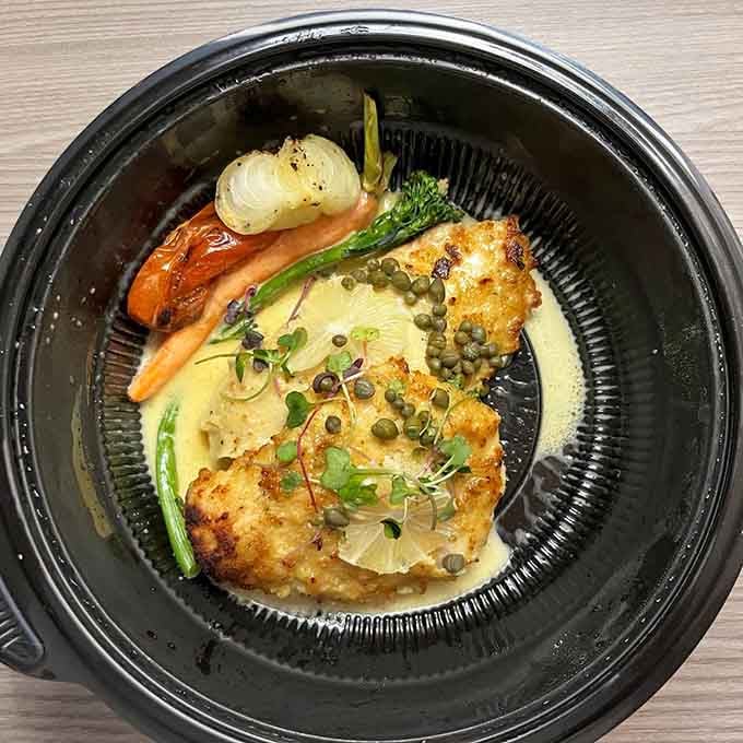 Chicken Lemonata plated like edible art, with capers and vegetables that make healthy eating look downright irresistible.