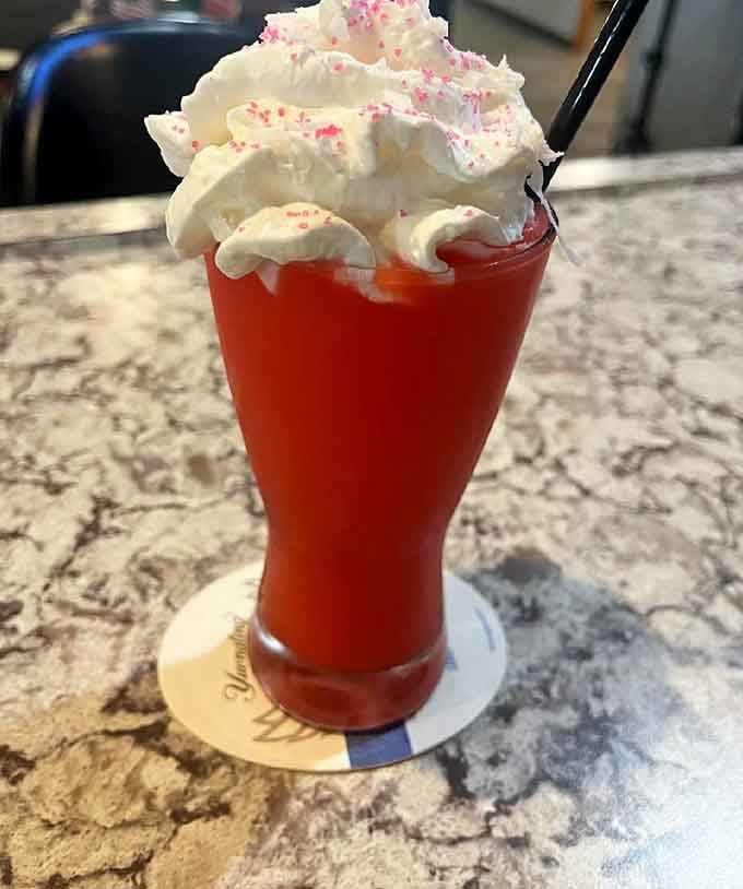 Whipped cream clouds top this ruby-red strawberry colada margarita, making happy hour feel like a tropical vacation.