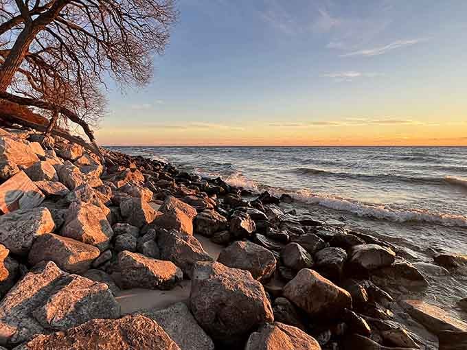 Sunset-kissed rocks along the shore create a scene worthy of your new phone wallpaper.