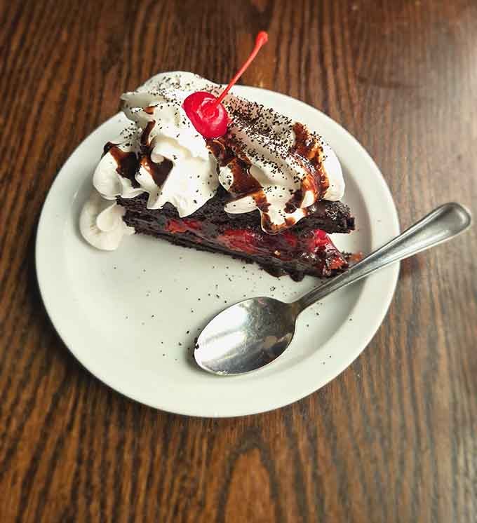 Black Forest Cake topped with a cherry and whipped cream, looking like a chocolate lover's fever dream come true.