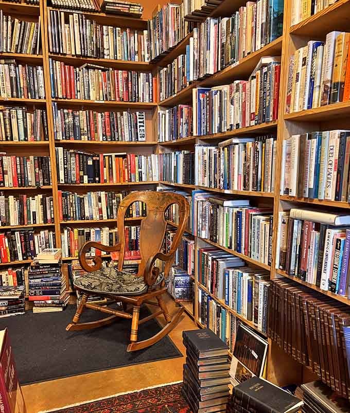 A wooden rocking chair nestled between shelves, perfect for testing whether that mystery novel keeps you awake.