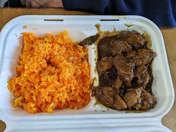 Tender adobo alongside vibrant rice proves this menu offers delicious surprises beyond traditional American barbecue favorites.