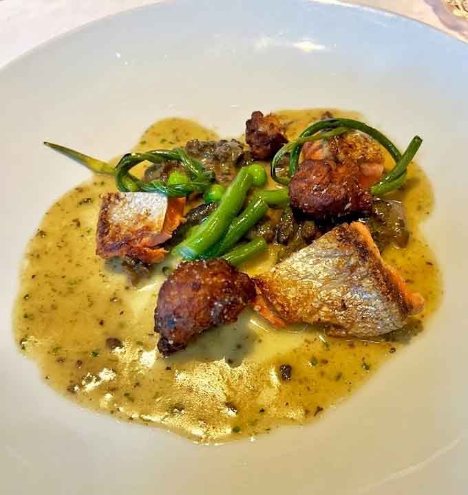 Salmon and scallops sharing plate space like old friends, swimming in sauce that deserves its own standing ovation.