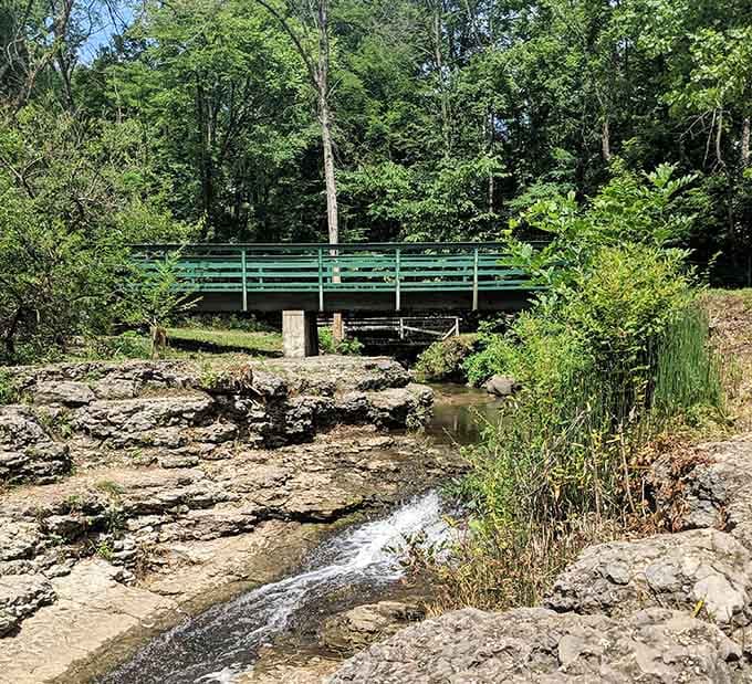 A charming bridge over the waterfall where limestone ledges create nature's own staircase to serenity and Instagram glory.
