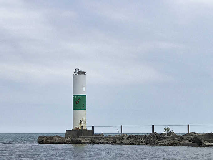 Standing sentinel over the harbor, this striped beacon guides boaters home like a trusty old friend.