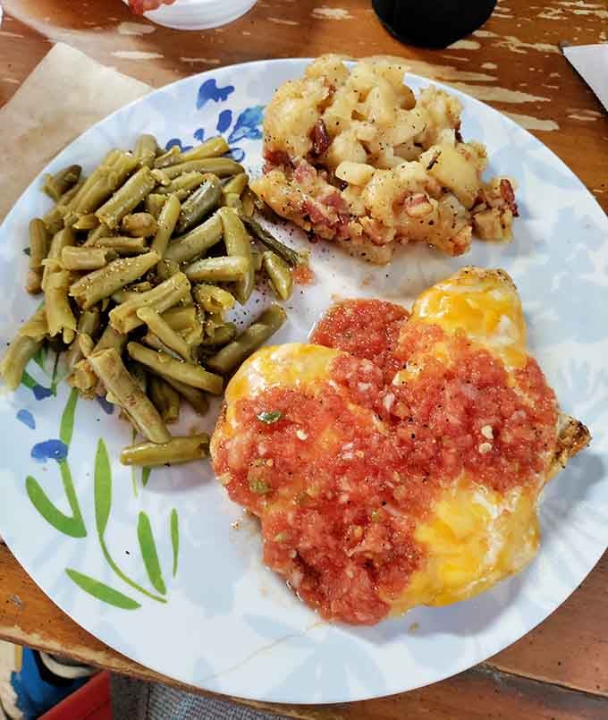 Smothered chicken with green beans and fried onion rings, comfort food that hugs you from the inside out.
