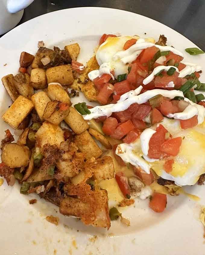 Eggs Benedict swimming in creamy hollandaise with crispy potatoes on the side: this is not a drill, people.