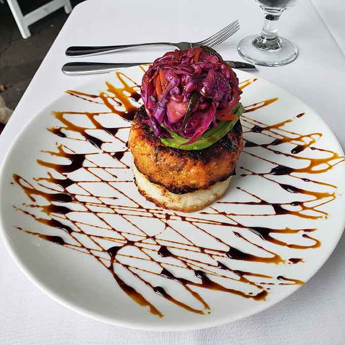 This crab cake sits pretty on its throne, drizzled with balsamic like edible art on a plate.