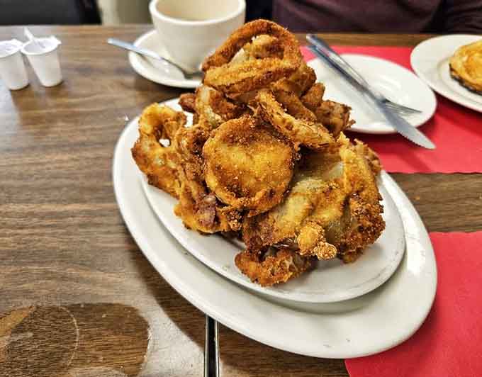These onion rings are piled high like edible architecture, golden and crispy beyond your wildest dreams.