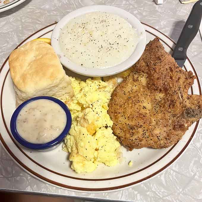 That pork chop with creamy grits and a fluffy biscuit is Southern breakfast cooking at its absolute finest.