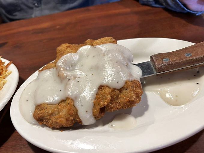 Country fried steak drowning in gravy like it's auditioning for a comfort food hall of fame induction.