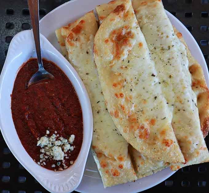 Mozzarella Breadsticks covered in alfredo sauce, because apparently regular breadsticks weren't already perfect enough on their own.