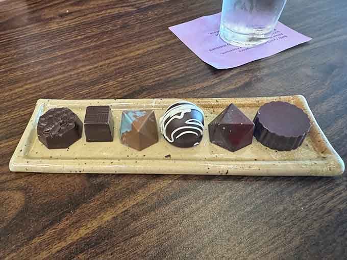 Six handcrafted bonbons arranged like edible jewels, each one a tiny masterpiece waiting to melt on your tongue.