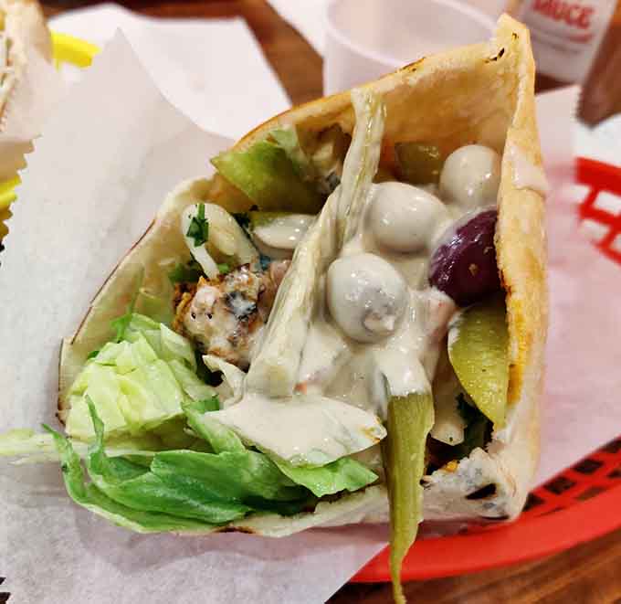That tahini drizzle cascading over grilled chicken is the kind of food photography that makes stomachs growl audibly.