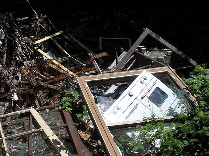 Even appliances get abandoned here, their white enamel finish a stark contrast to the chaos of collapsed dreams and timber.
