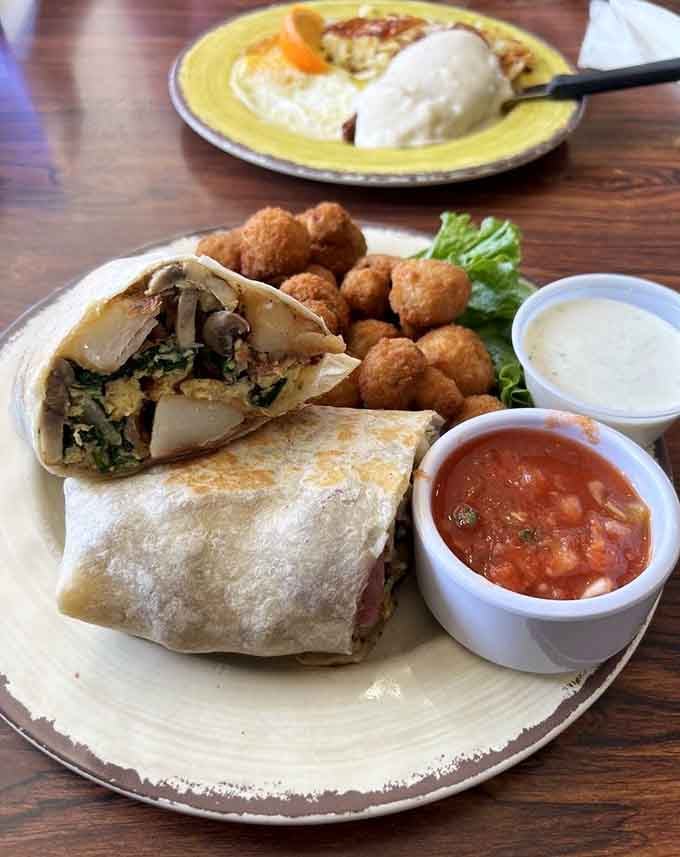 A breakfast burrito so generously stuffed it requires strategic planning and possibly both hands to navigate successfully.