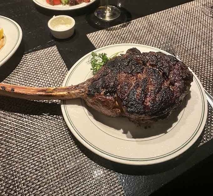 The tomahawk steak arrives like a prehistoric drumstick, making Fred Flintstone's dinner look downright modest by comparison.