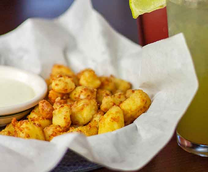Those golden cheese curds glisten like edible treasure, perfectly seasoned and begging to be devoured immediately.