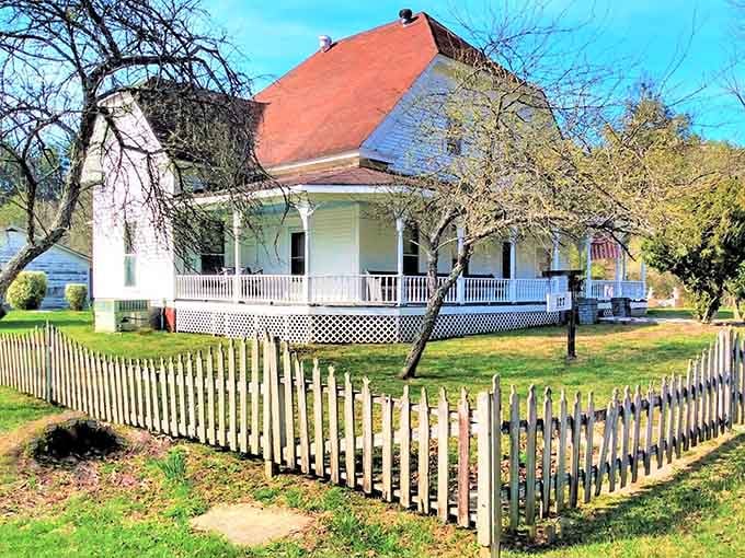 This classic white picket fence frames a historic home that looks like it stepped straight from a Southern postcard.