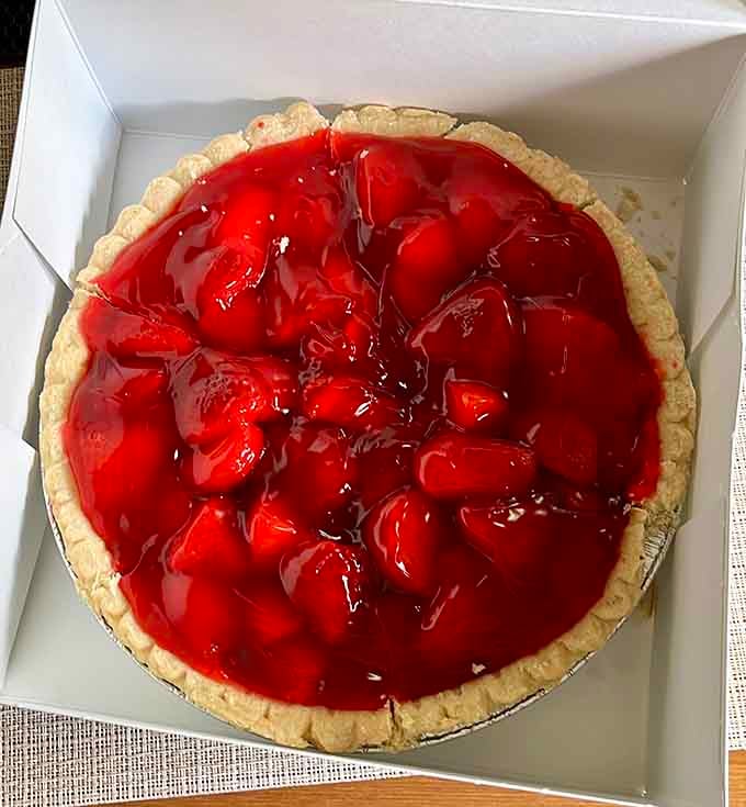 A whole strawberry pie waiting to make someone's day infinitely better, one glossy red berry at a time.