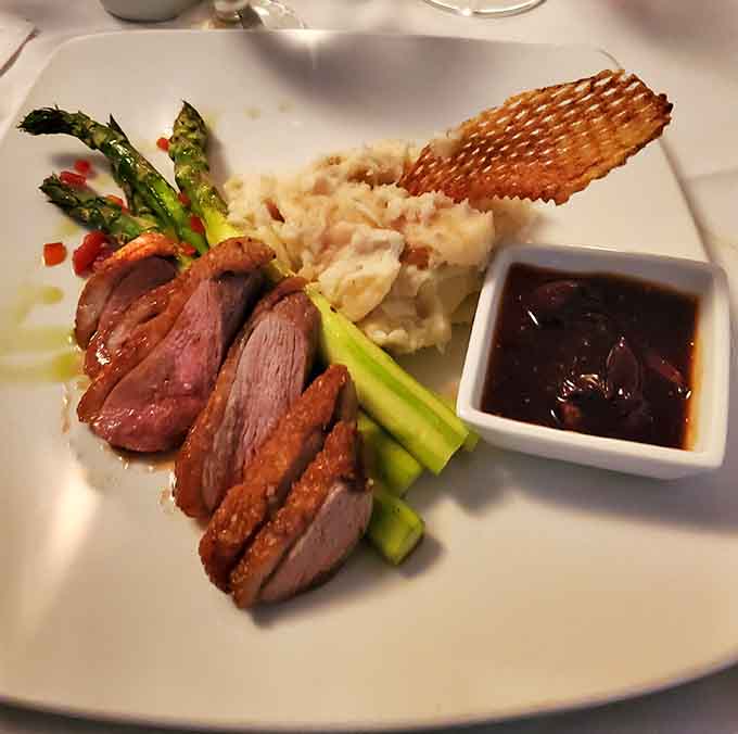 Duck breast fanned out like edible art, because sometimes your dinner deserves to look as magnificent as it tastes.