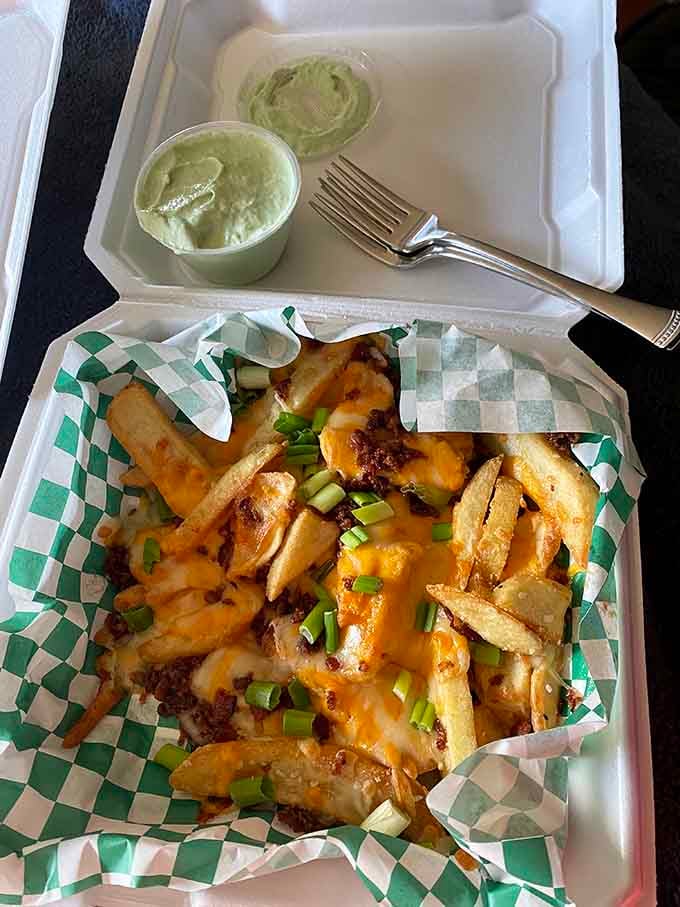 Loaded fries topped with cheese and green onions, because sometimes more really is more and that's perfectly okay with us.