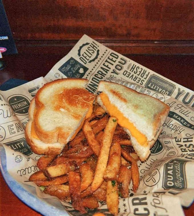Golden grilled cheese paired with crispy fries on vintage-style paper makes comfort food look downright artistic.