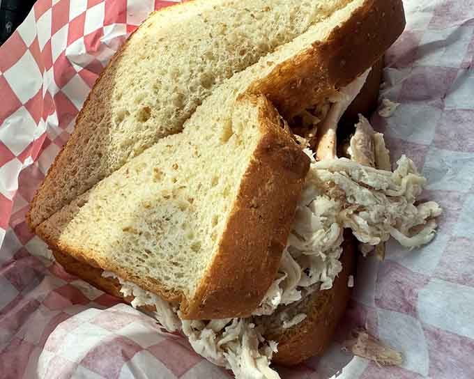 Tender turkey and toasted bread in classic red-checkered paper, the kind of sandwich that satisfies completely and honestly.