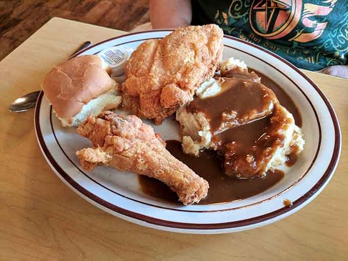 Golden fried chicken with mashed potatoes swimming in gravy, like Sunday dinner at grandma's house every day.