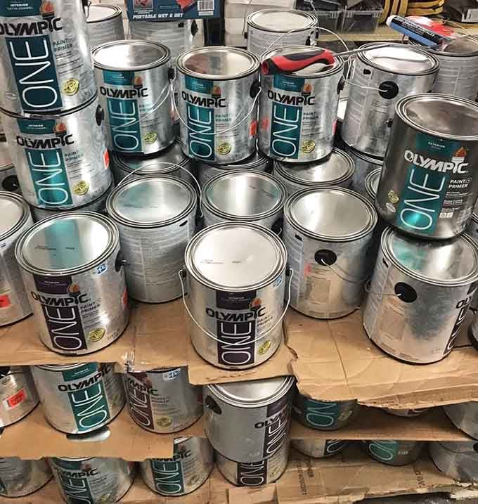 Olympic paint cans stacked like treasure, ready to transform your walls for a fraction of the usual cost.