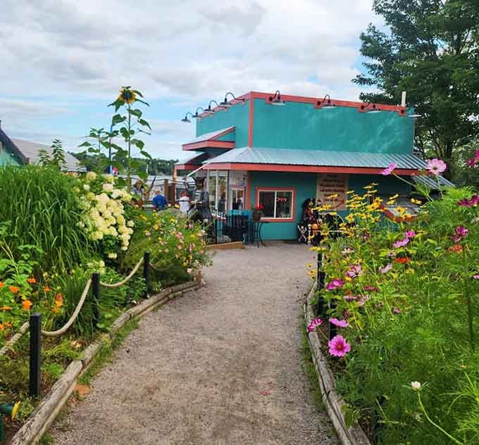 Vibrant flowers guide you toward the turquoise building, because even pirates appreciate a well-maintained garden path to their hideaway.