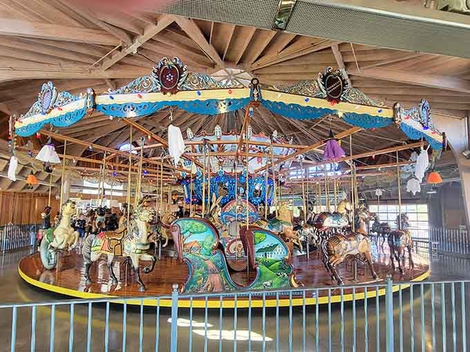 Fifty-two hand-carved animals circle endlessly under exposed beams, creating a kaleidoscope of color that cameras can barely capture.
