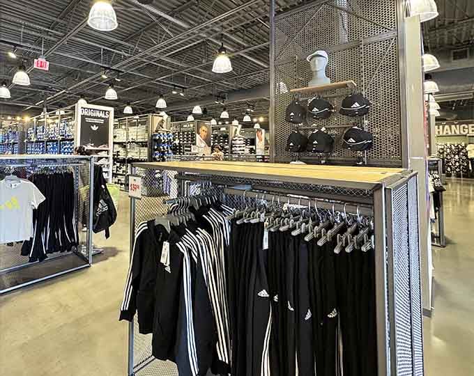 Adidas apparel hanging in perfect formation, where those iconic three stripes come at prices that won't leave you striped of cash.