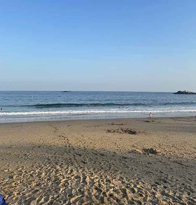 Late afternoon light casts golden shadows across sand that stretches invitingly toward the distant horizon line.